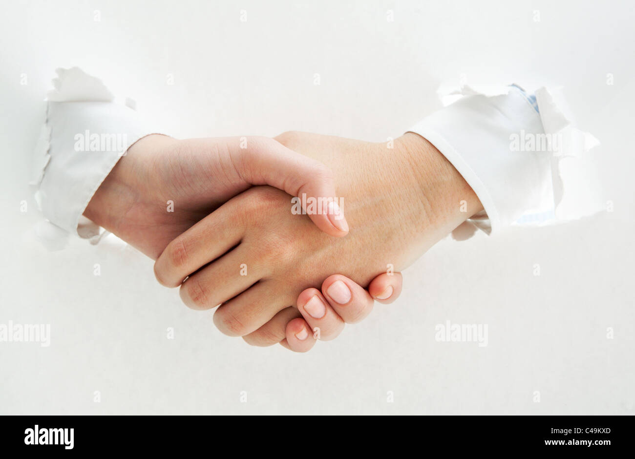 Photo of handshake of business partners through torn paper Stock Photo ...
