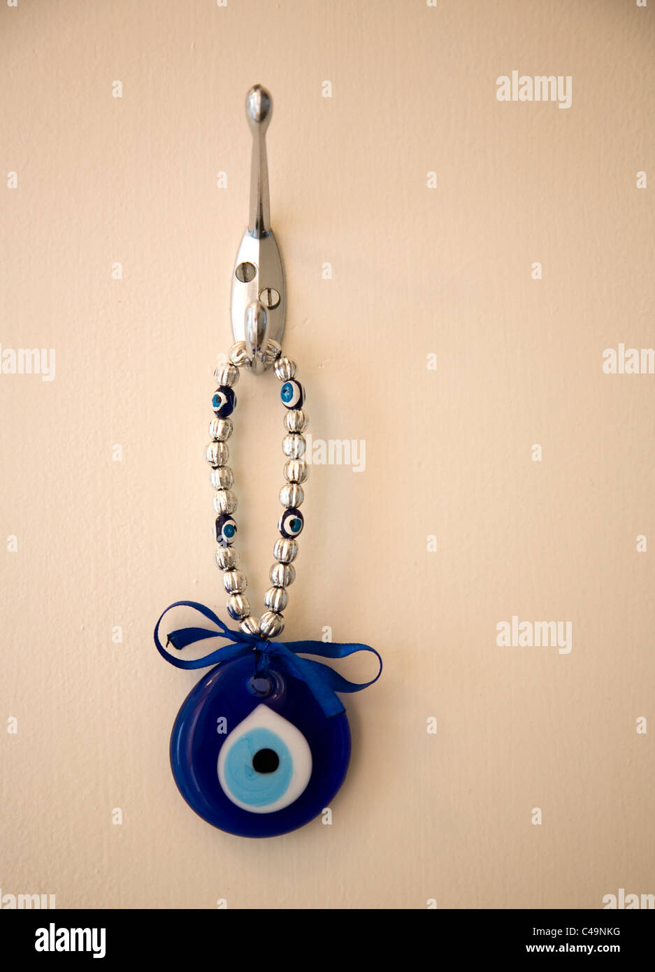 Glass evil eye hanging from hook Stock Photo - Alamy