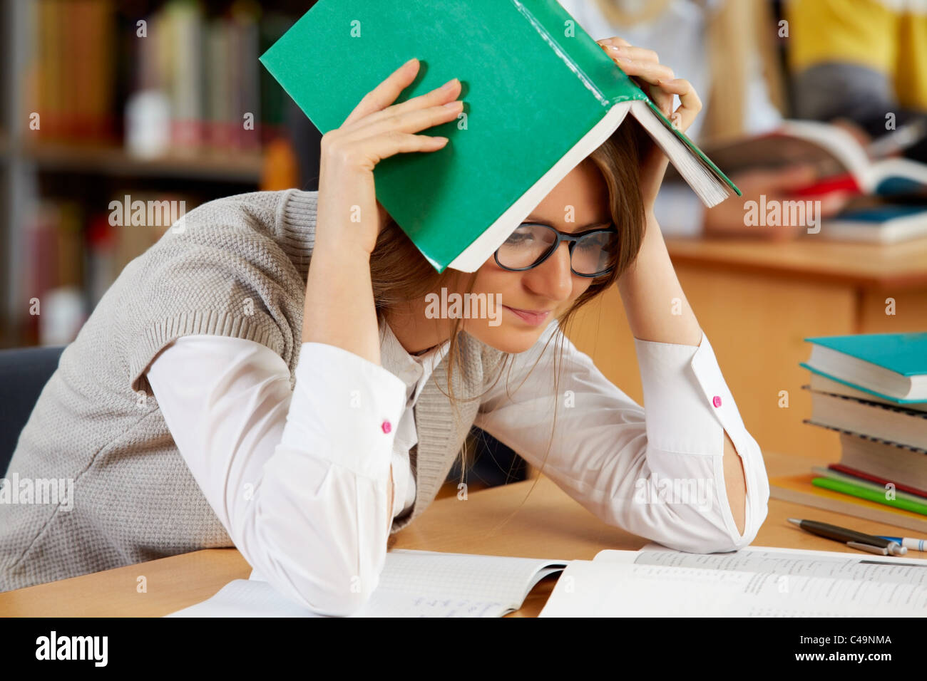 Portrait of clever student reading book in college library Stock Photo ...