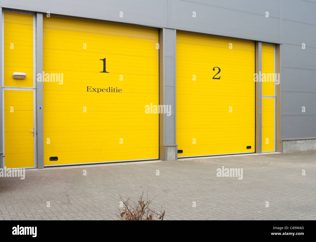industrial warehouse with yellow roller doors Stock Photo - Alamy