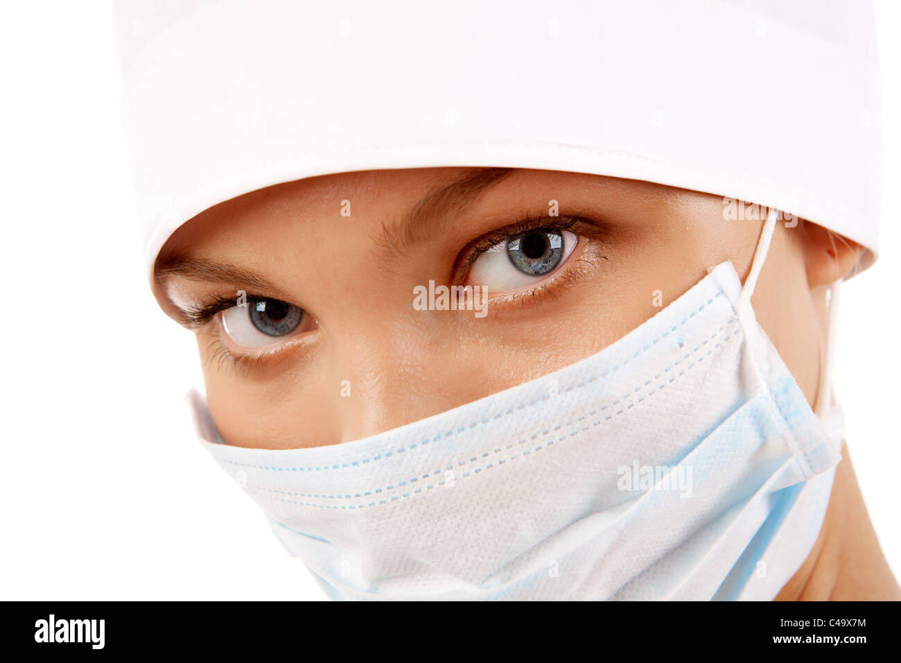 Face of nurse in sterile mask looking at camera over white background ...