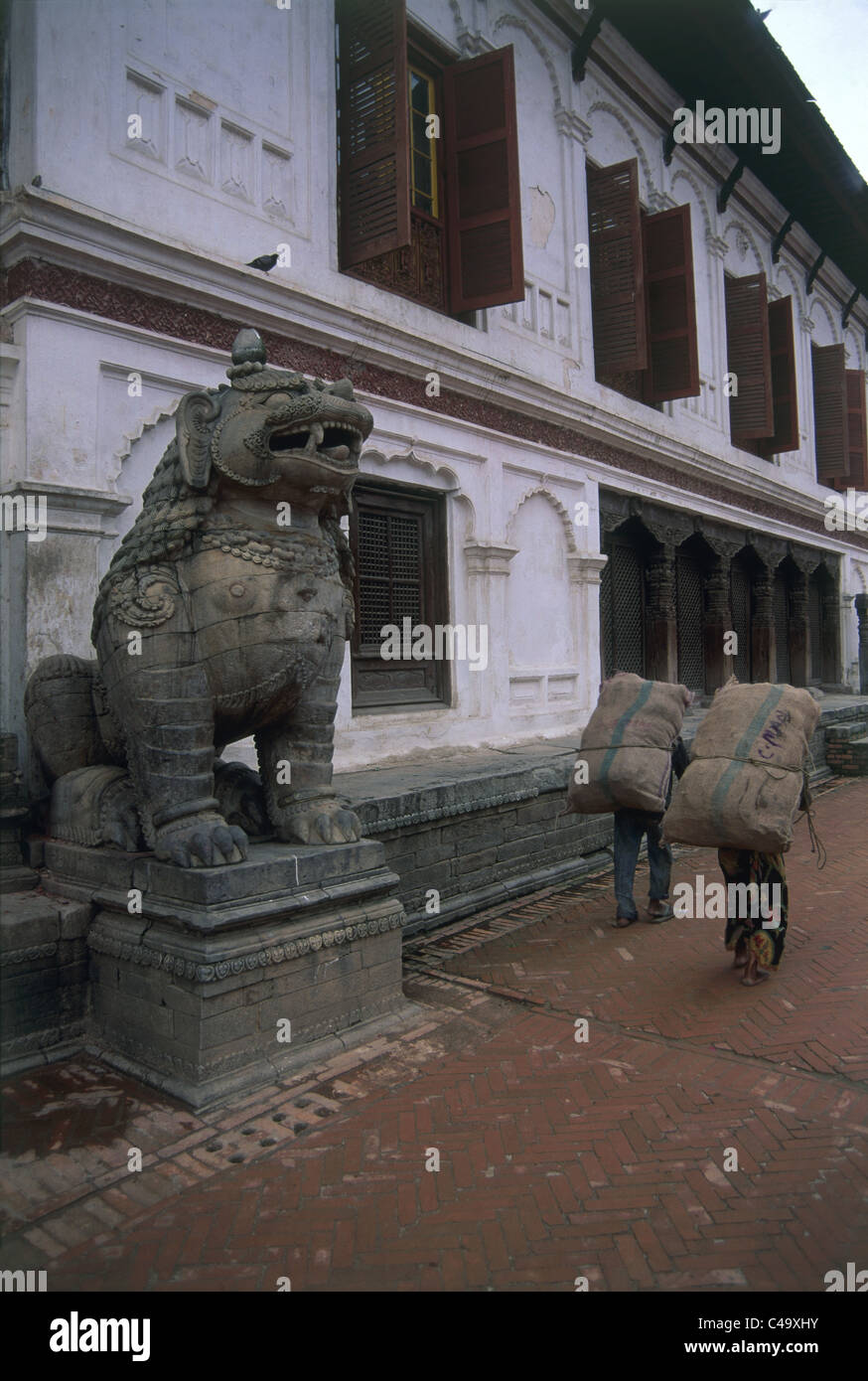 Photograph of two men carrying huge sacks in Tibet Stock Photo - Alamy