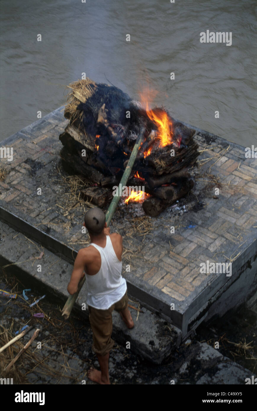 Photograph of a man lighting a fire for religion purposes in Nepal ...