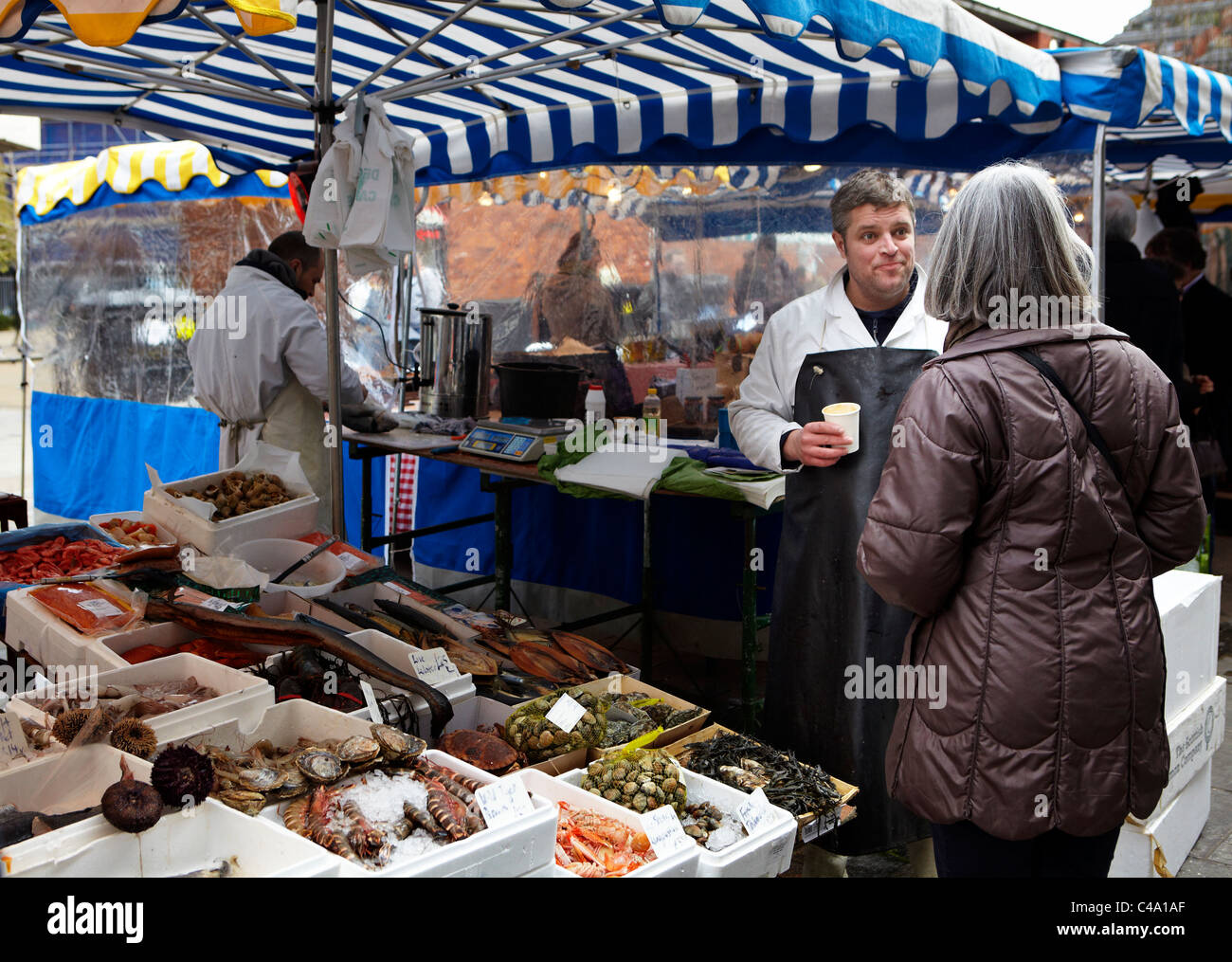 A traditional fishmonger sellsing fish from his market stall in London ...
