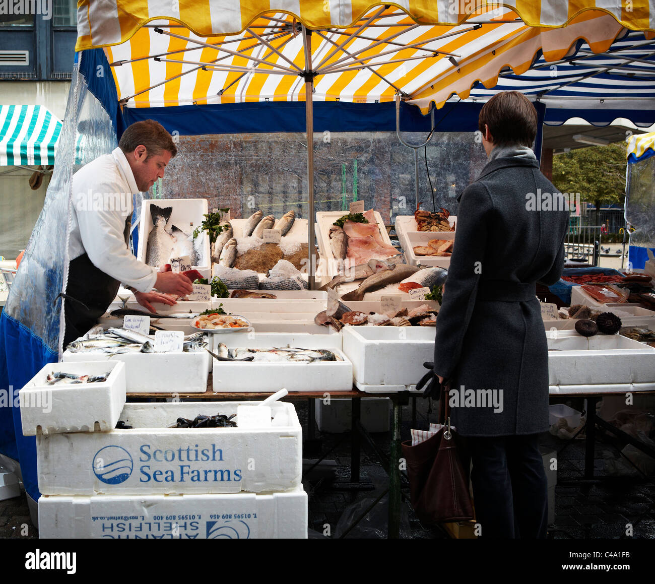 A traditional fishmonger sellsing fish from his market stall in London ...