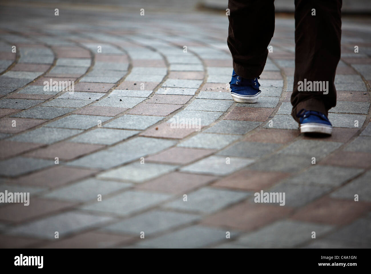 Close up of a man walking along a pavement Stock Photo - Alamy