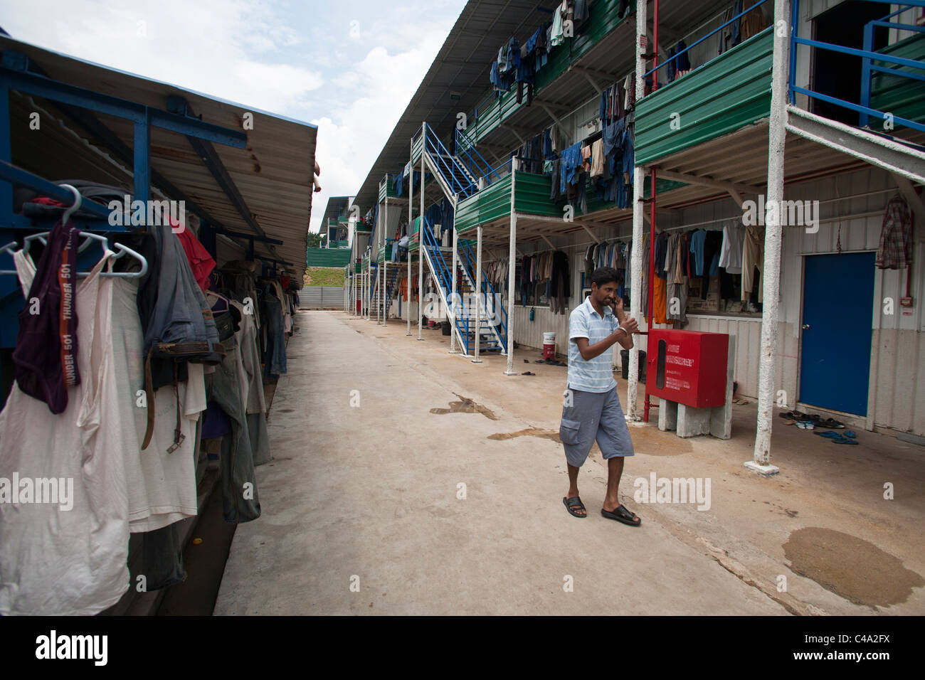 A man walks past drying clothes at a dormitory for foreign workers in ...