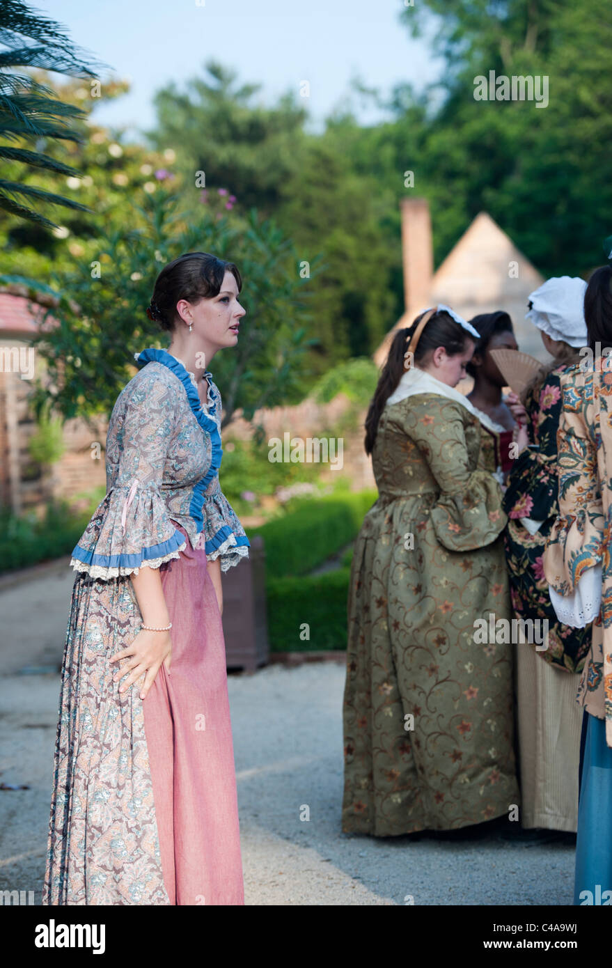 Dancers dressed in eighteenth century clothing gathered in a courtyard ...
