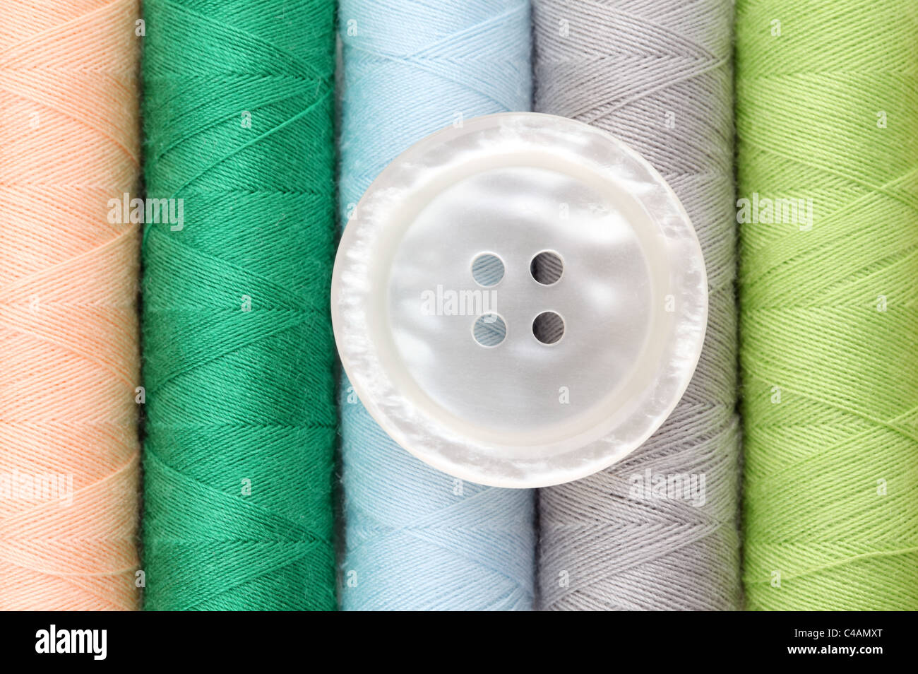 Colorful spools of thread and button, background texture Stock Photo ...