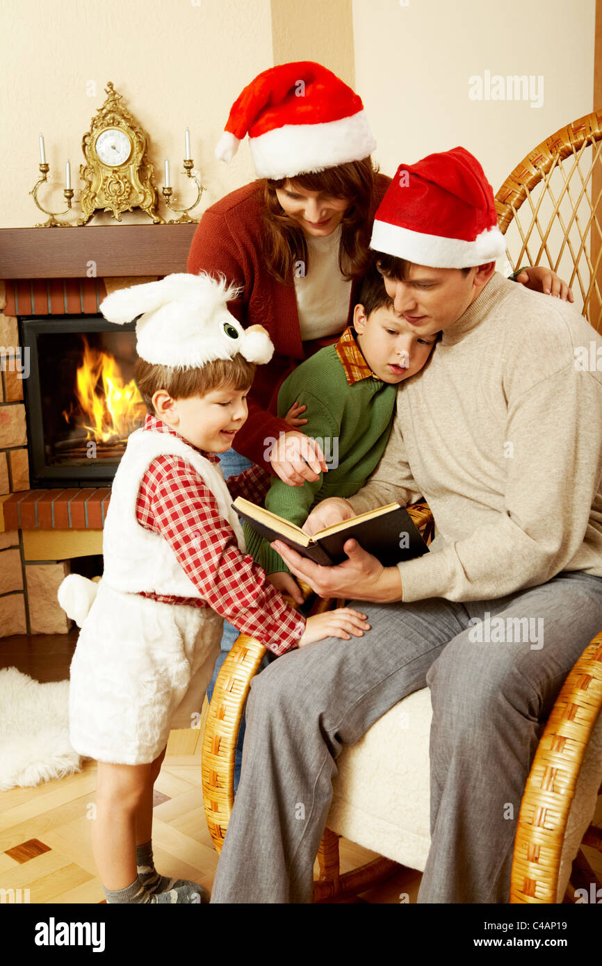 Portrait of family gathered together to read interesting fairy tale ...