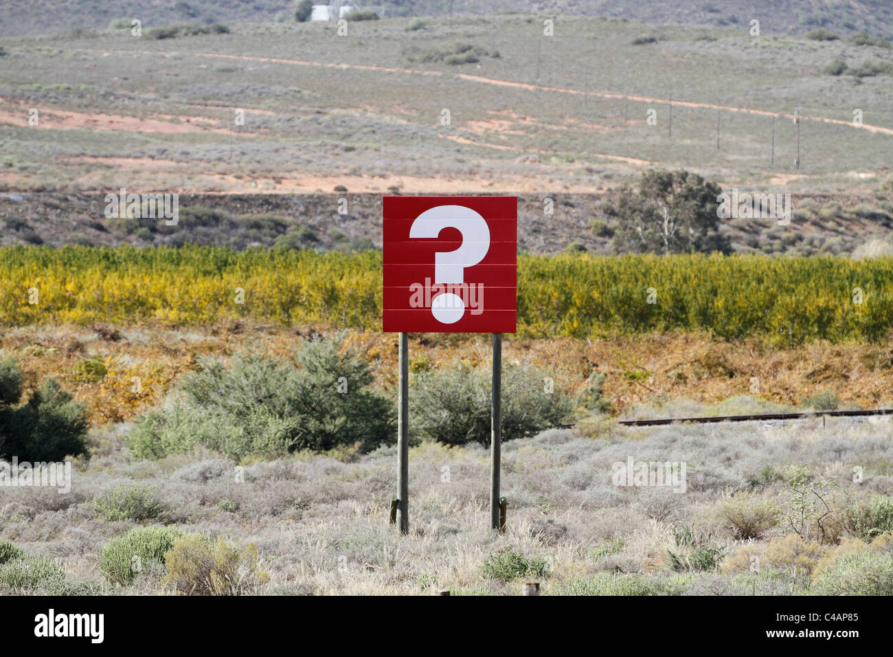 White question mark on red billboard next to the national road in the ...