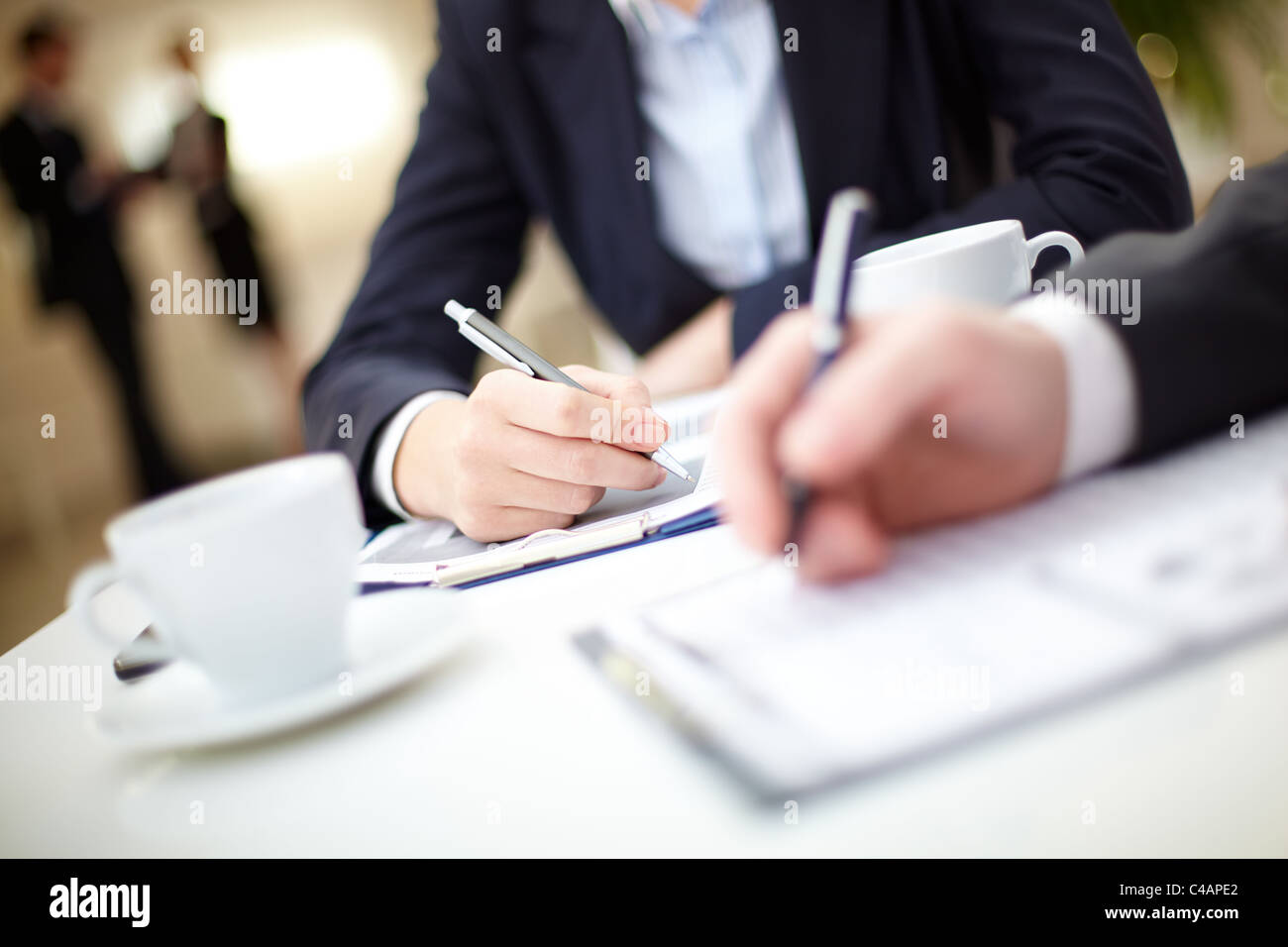 Human hand writing on paper in working environment Stock Photo - Alamy