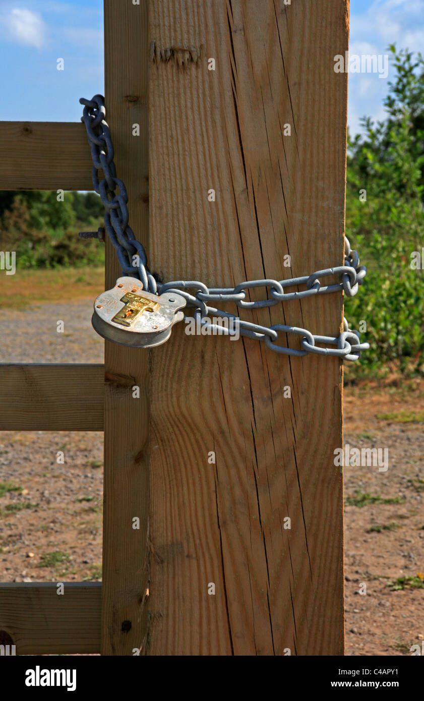 Padlock and chain on a gate post Stock Photo - Alamy