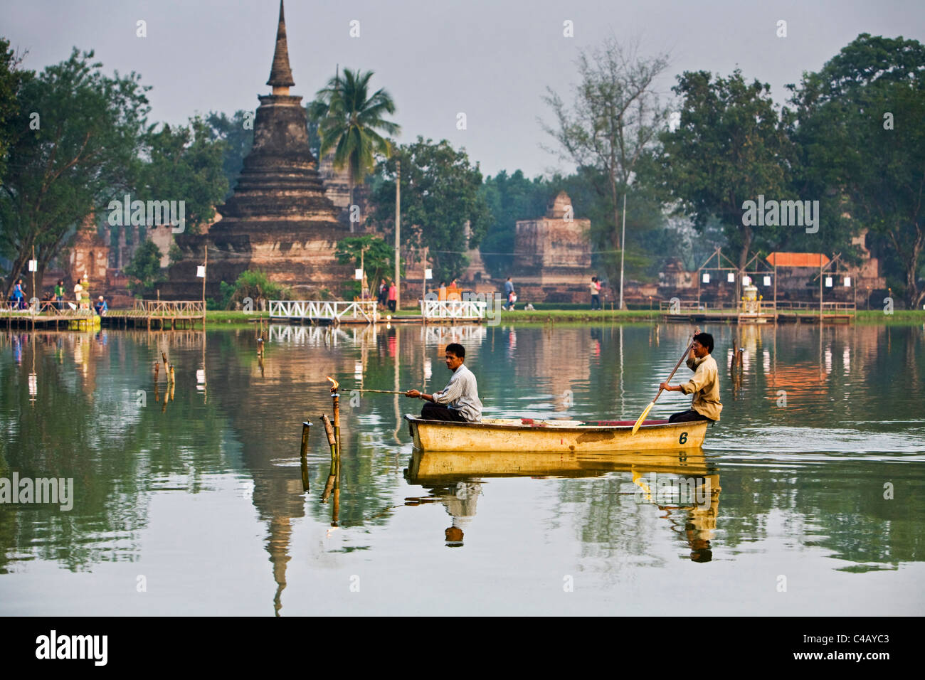 Thailand, Sukhothai, Sukhothai. Workers light water torches at the ...