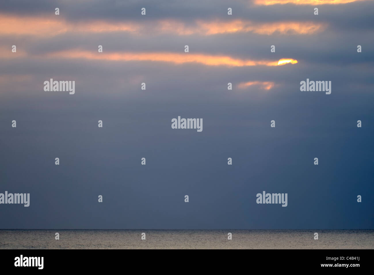 A glowing rising sun peeking out through the gap between the dawn ...