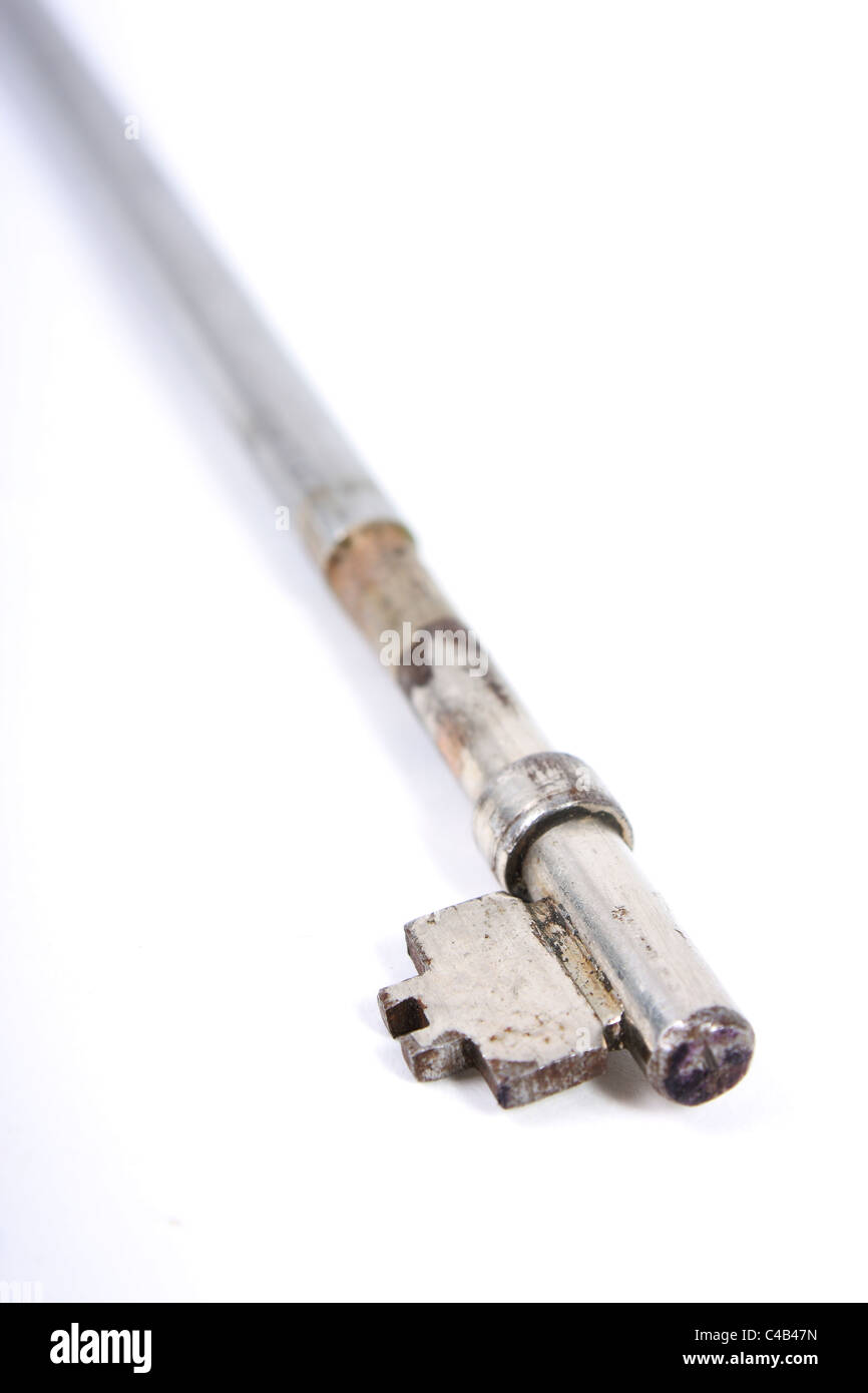 A long metal silver coloured key for a gate used to secure an area or ...