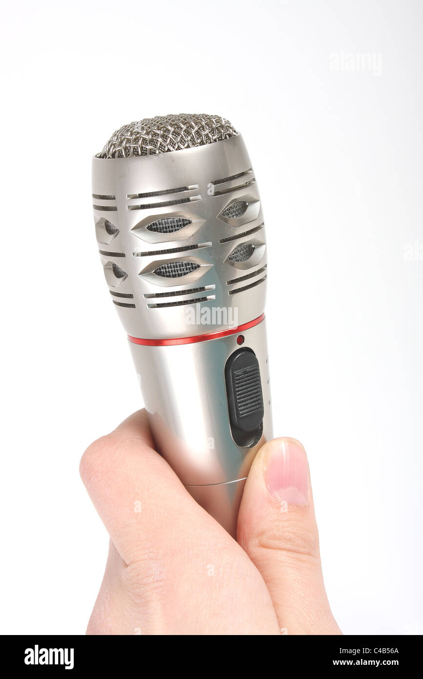 A Caucasian female holding a silver microphone on a cut out white ...