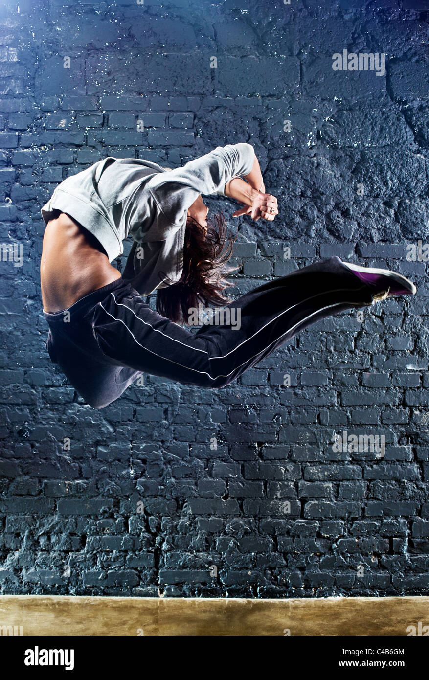 Young woman dancer jumping. On wall background Stock Photo - Alamy