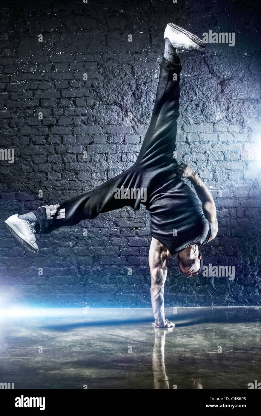 Young strong man break dance. On dark wall background Stock Photo - Alamy