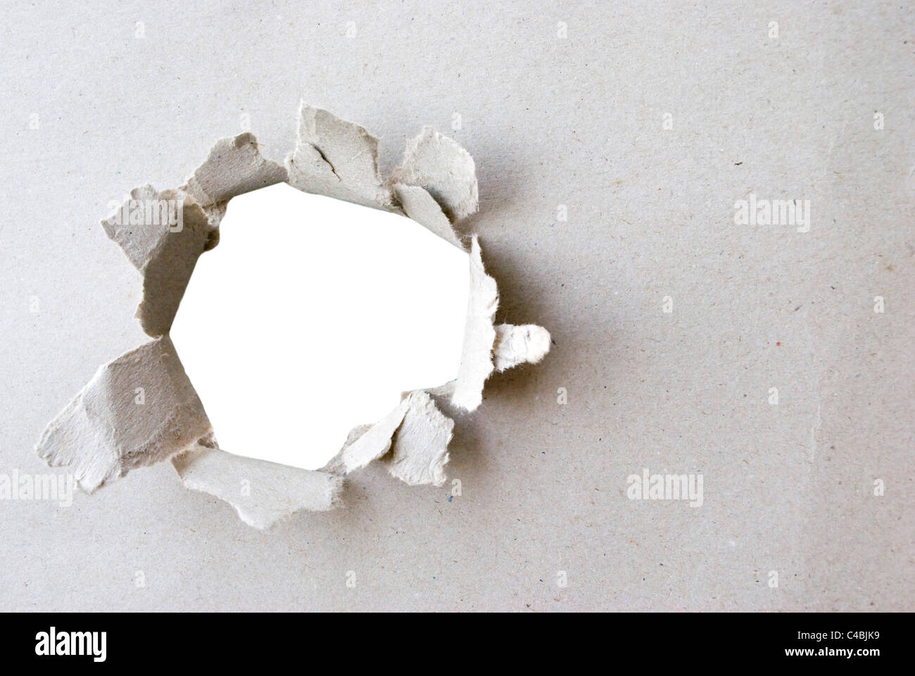torn hole in sheet of paper with white background and copyspace Stock ...