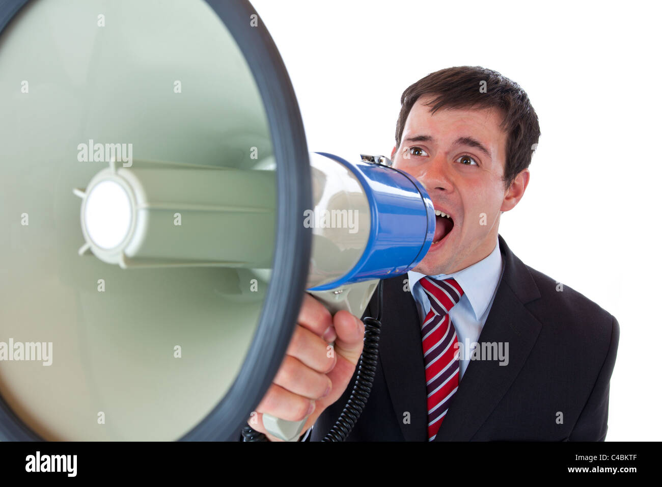 Closeup of a businessman roaring loudly into megaphone.Isolated on ...