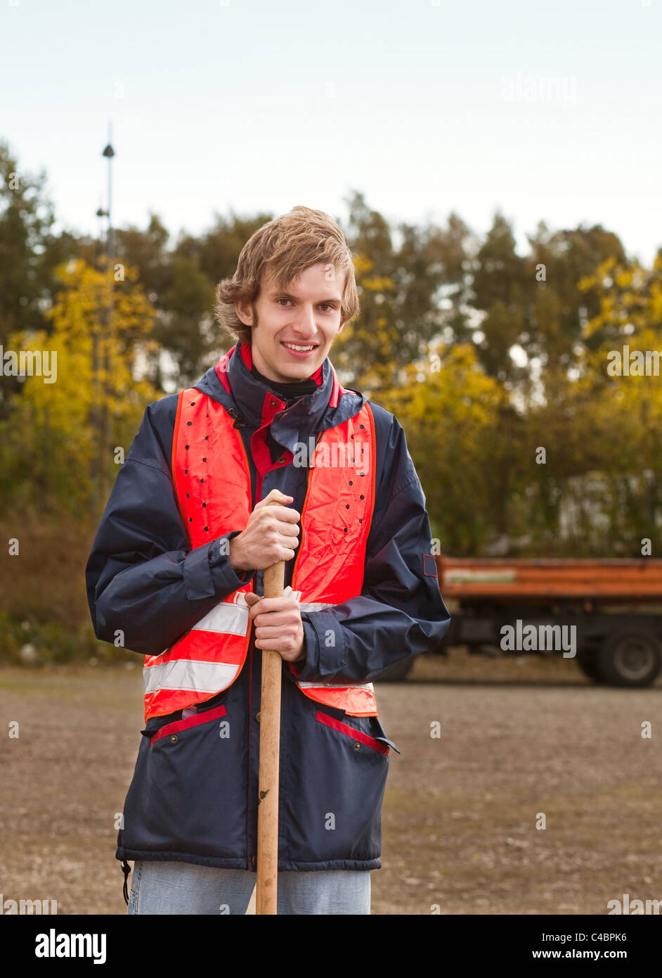 Young manual worker with shovel standing outdoor Stock Photo - Alamy