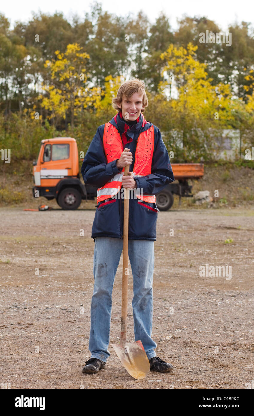 Young manual worker with shovel standing outdoor Stock Photo - Alamy
