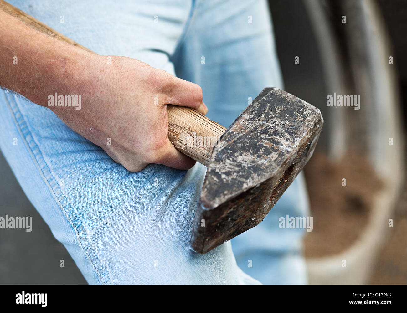 Male hand holding large heavy hammer; selective focus Stock Photo - Alamy