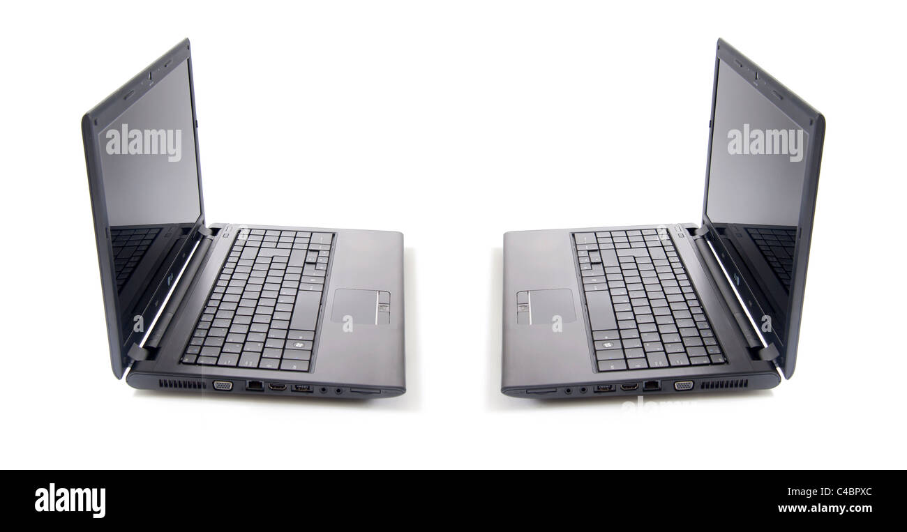 A side-profile view of two black laptops which facing each other with ...