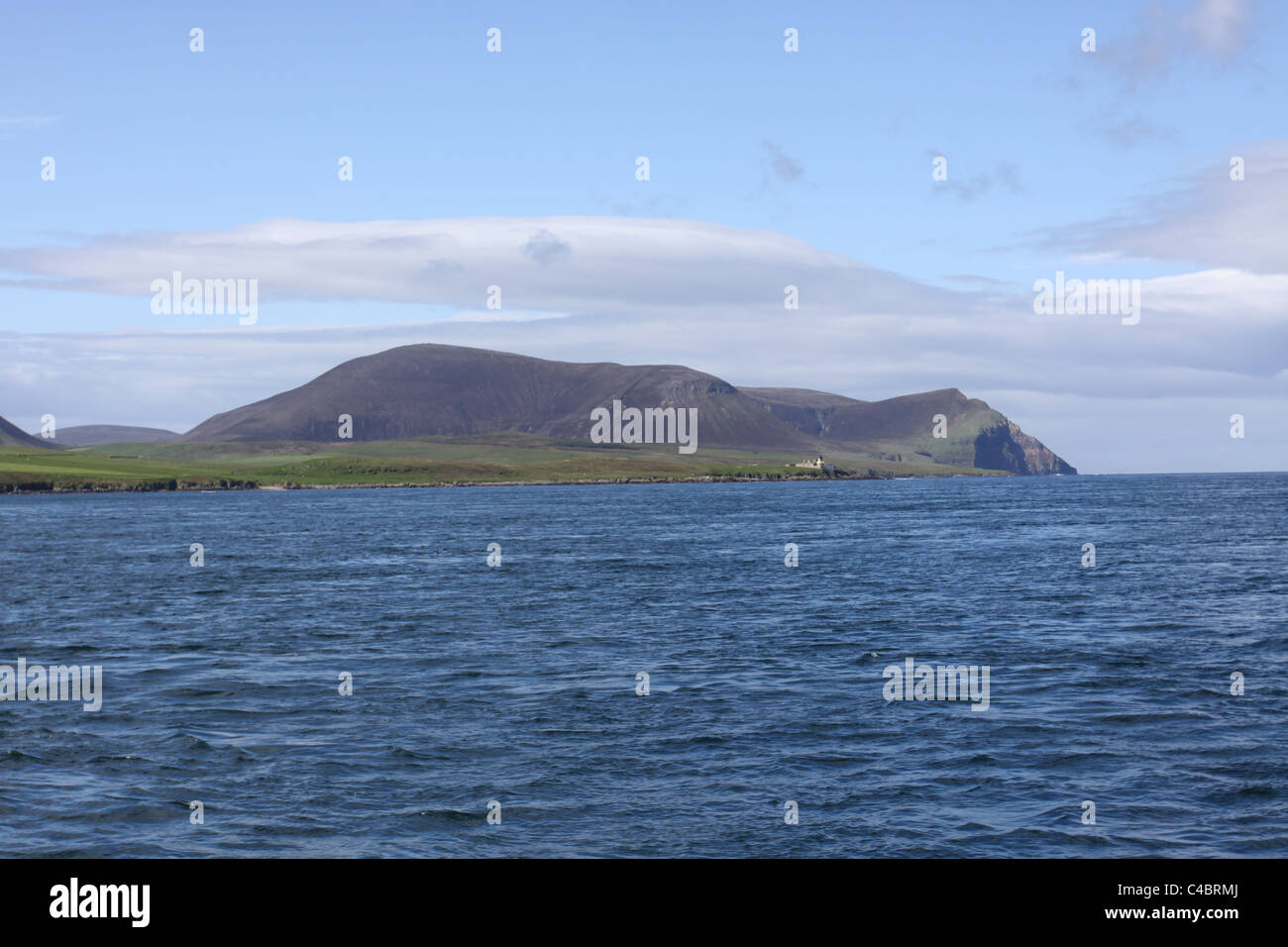 Distant view of Hoy Low Lighthouse, Graemsay with hills of Hoy behind ...