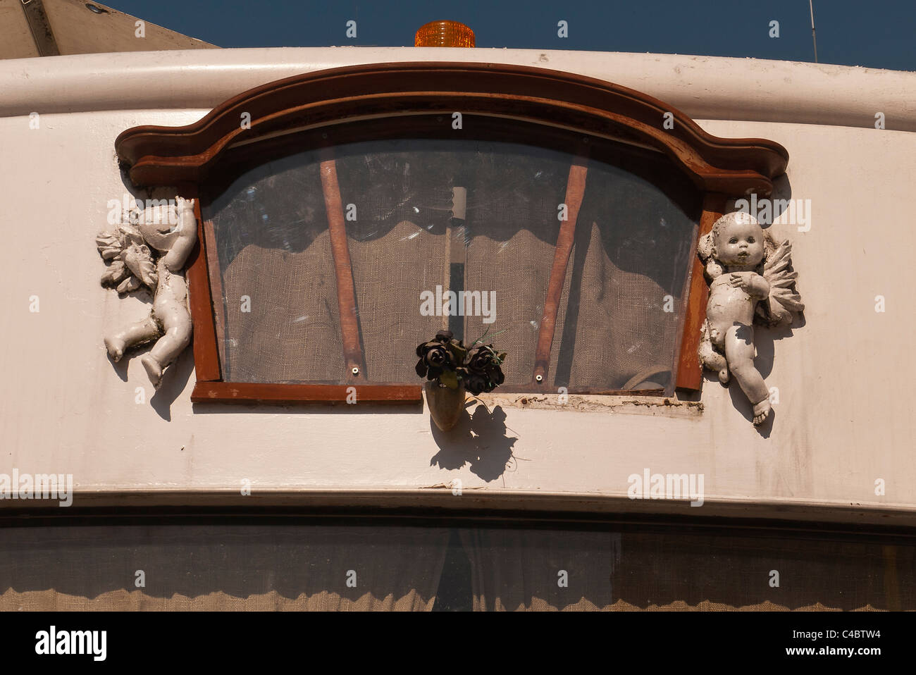 Detail, front of an old German recreational vehicle, window with cupids ...