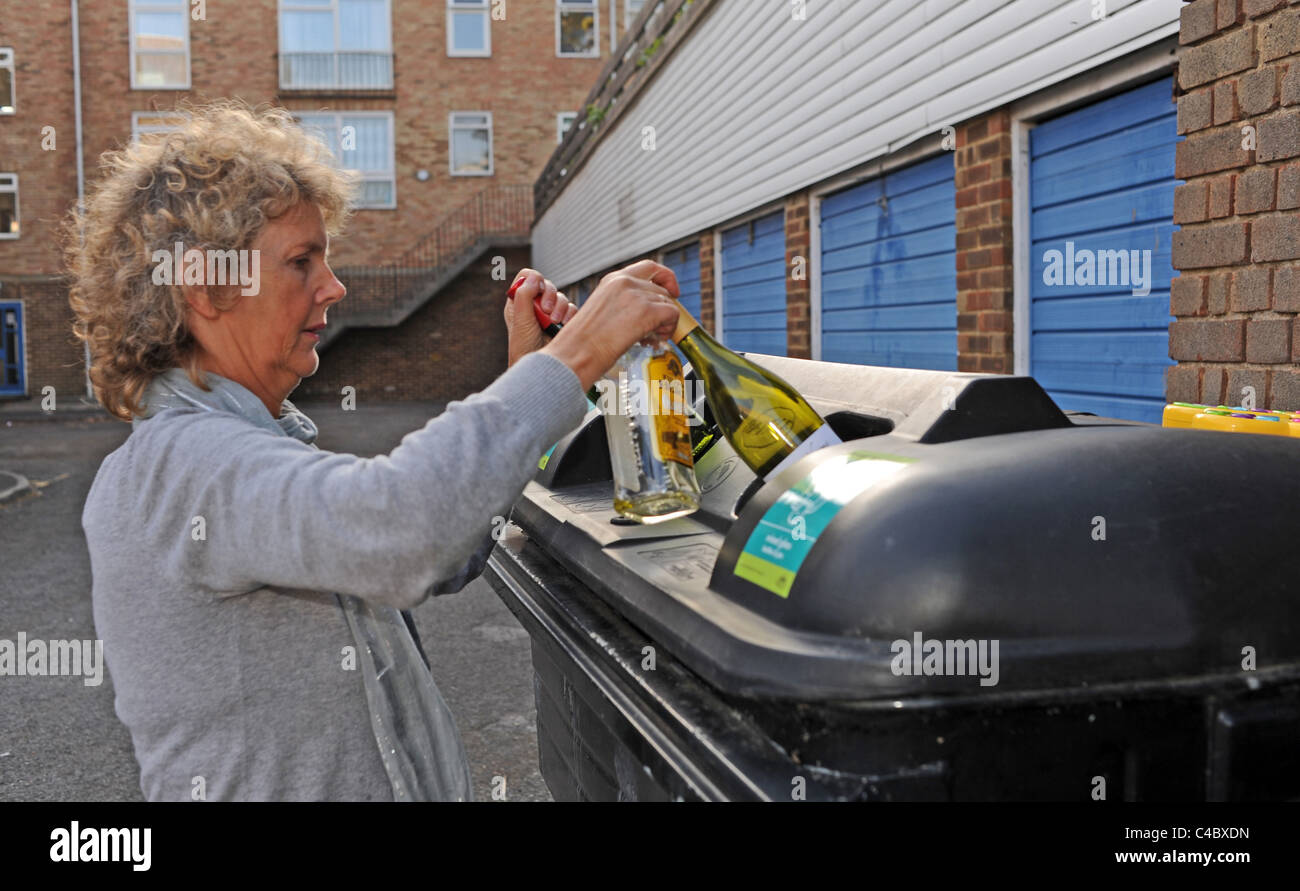Middle aged woman with a box of bottles and cans for recycling in the ...