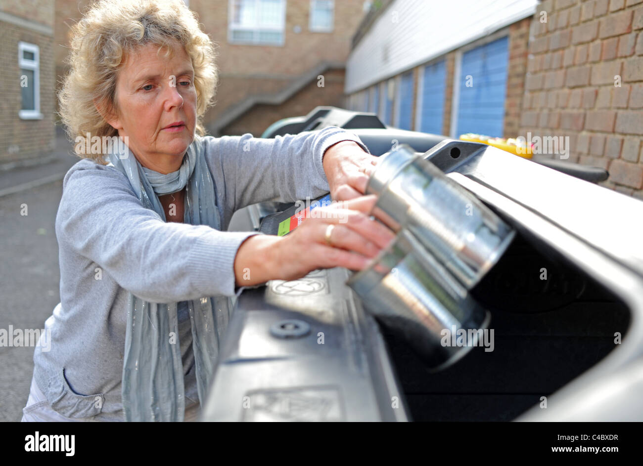 Middle aged woman with a box of bottles and cans for recycling in the ...