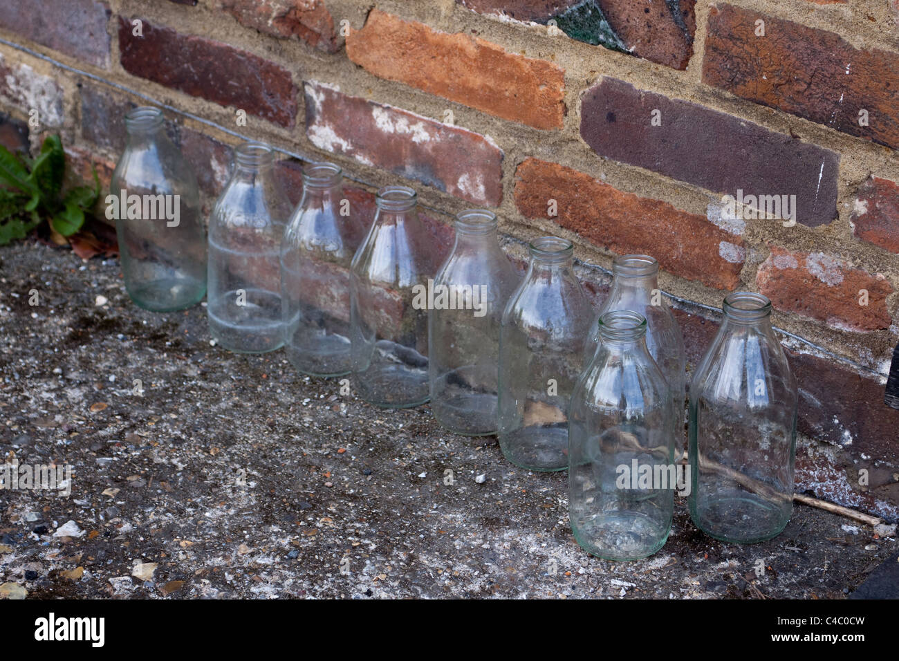 A row of milk bottles against a wall Stock Photo - Alamy