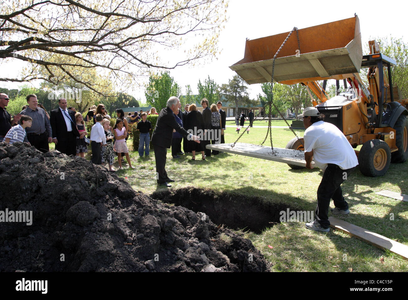 Digger filling grave of family member with turf in Texas USA Stock ...
