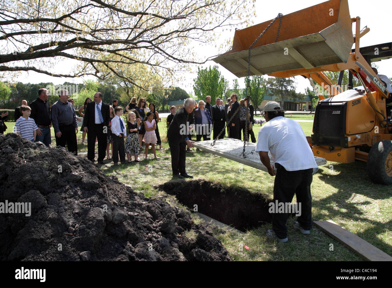 Digger filling grave of family member with turf in Texas USA Stock ...