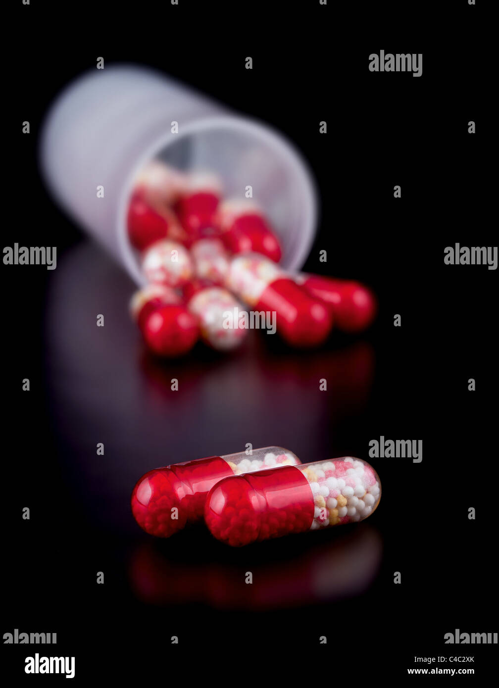 Red pills isolated on black background Stock Photo - Alamy