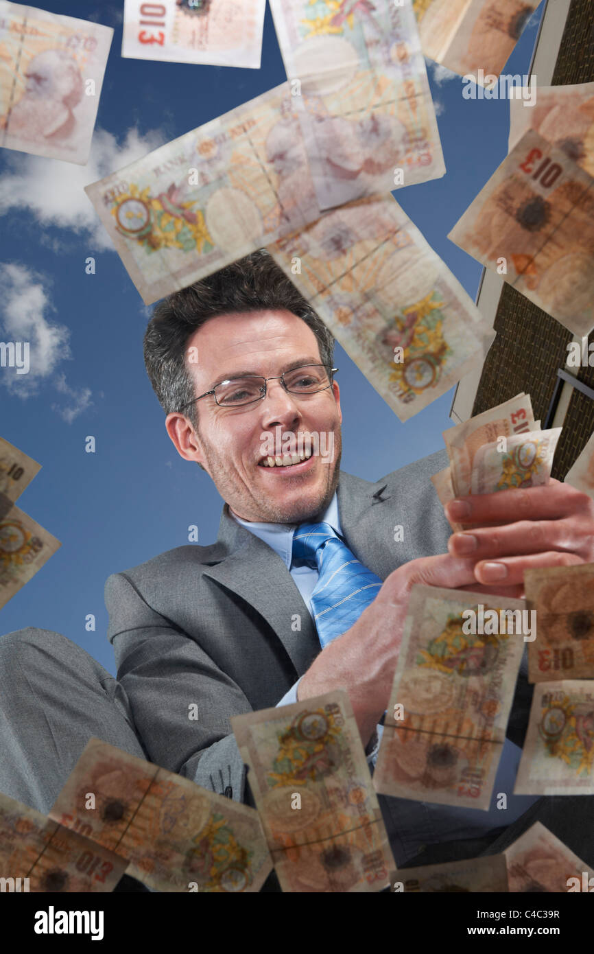 Businessman picking up discarded money Stock Photo - Alamy
