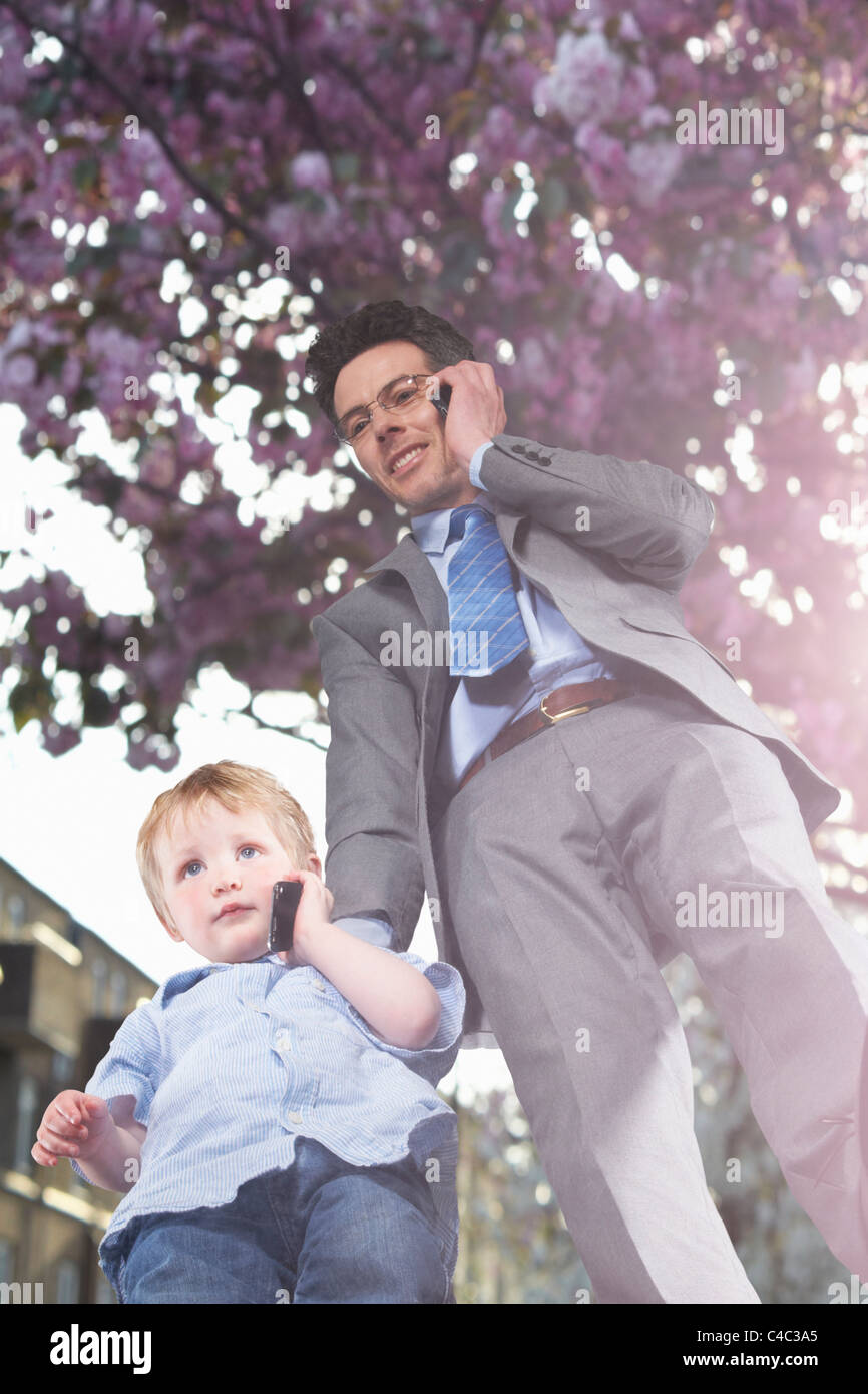 Father and son talking on cell phones Stock Photo - Alamy