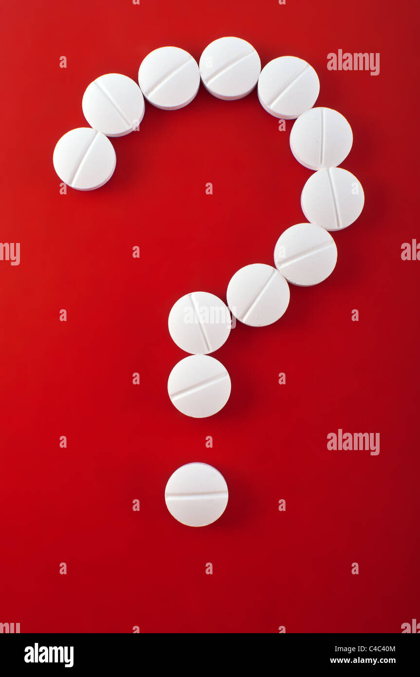 White tablets on red background as question mark Stock Photo - Alamy