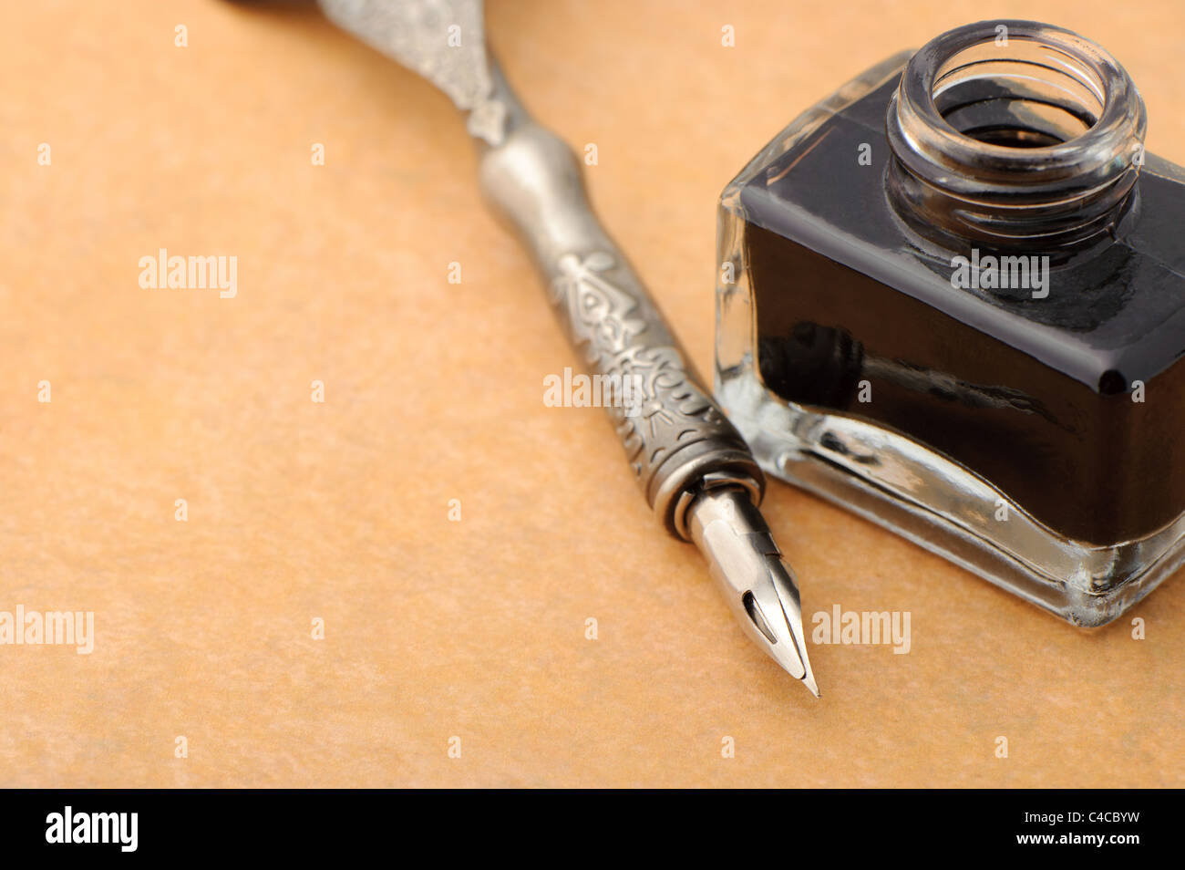 Feather quill and inkwell on an old paper. Photo closeup Stock Photo ...
