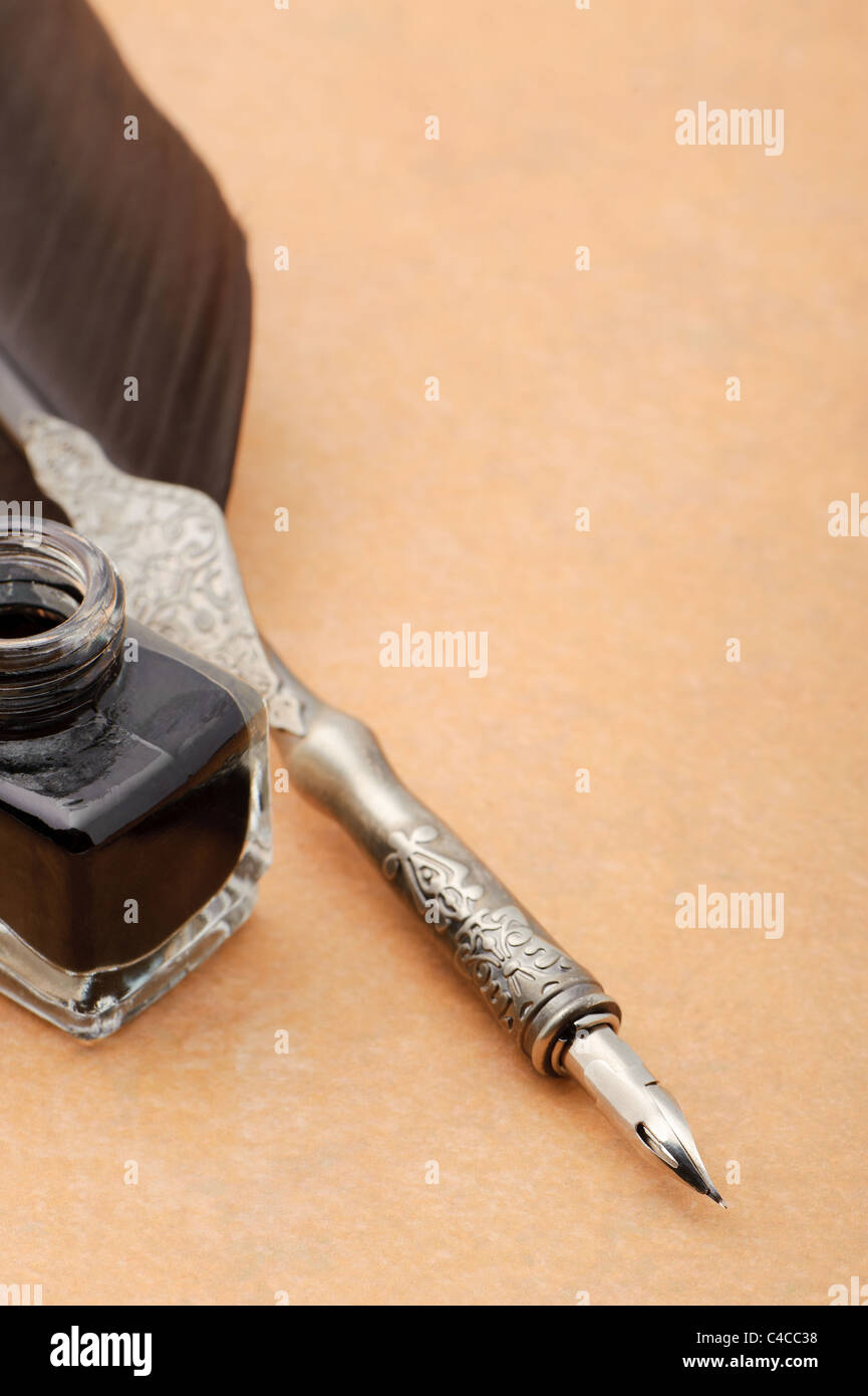 Feather quill and inkwell on an old paper. Photo closeup Stock Photo ...