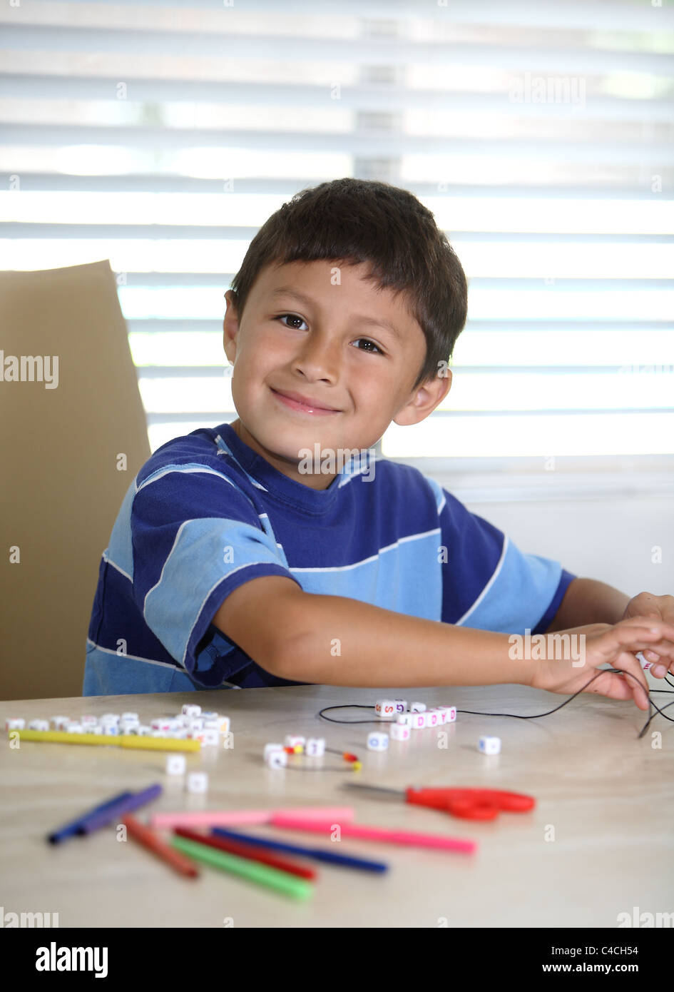 Happy Hispanic or Latino boy playing at crafts Stock Photo - Alamy