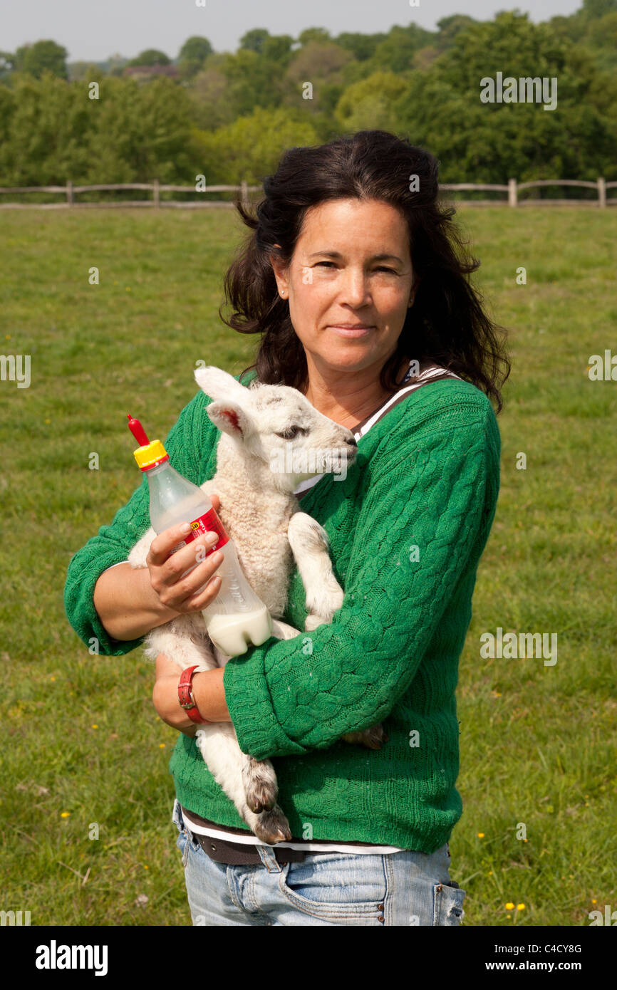Woman feeding a young lamb Stock Photo - Alamy