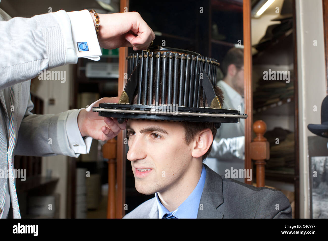 Man with conformateur device on head whilst having head measured for ...