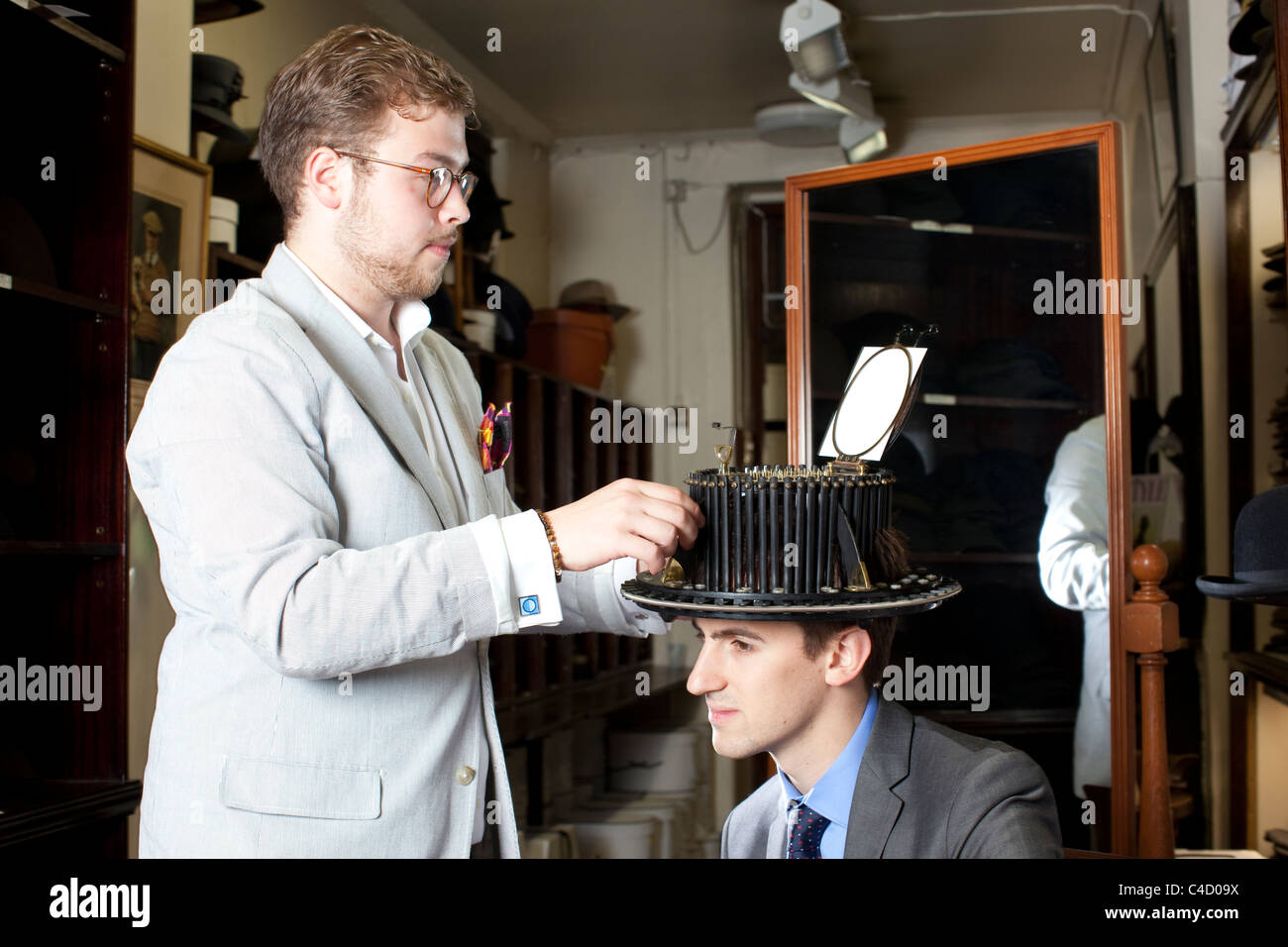 Man with conformateur device on head whilst having head measured for ...