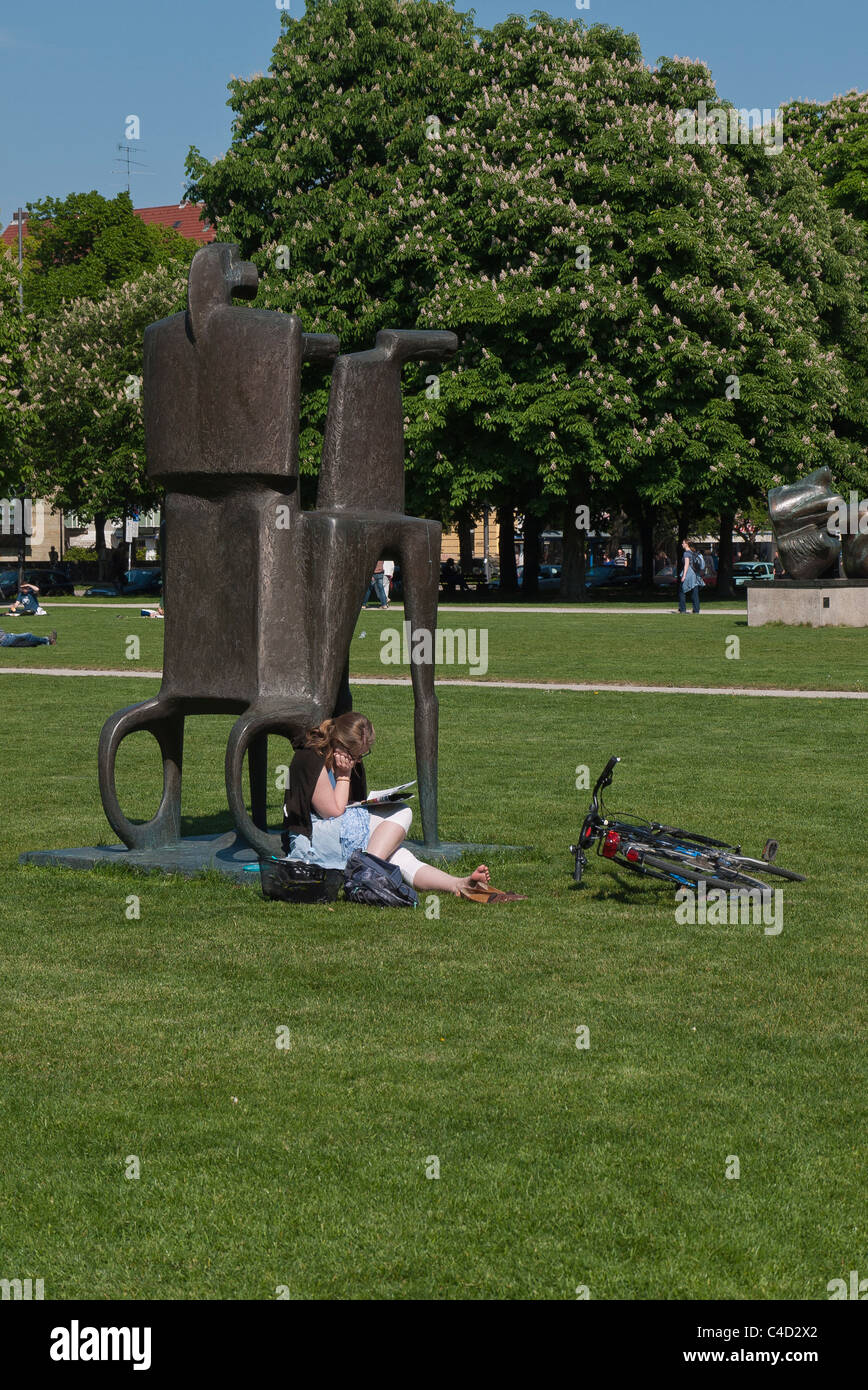 A German university student studies at the base of a sculpture in the ...
