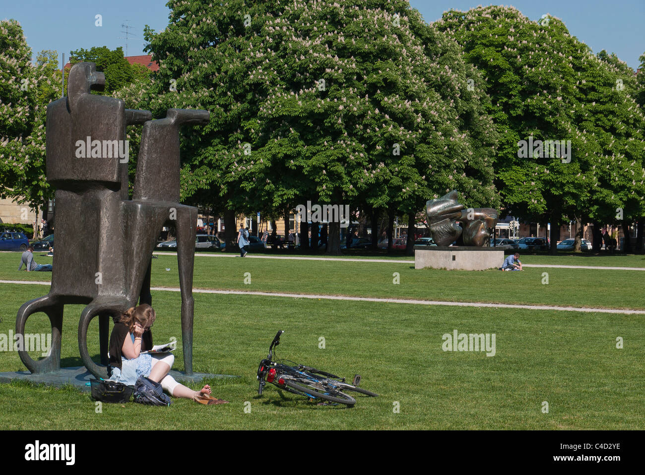 A German university student studies at the base of a sculpture in the ...