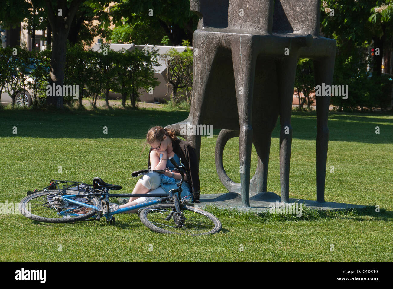 A German university student studies at the base of a sculpture in the ...