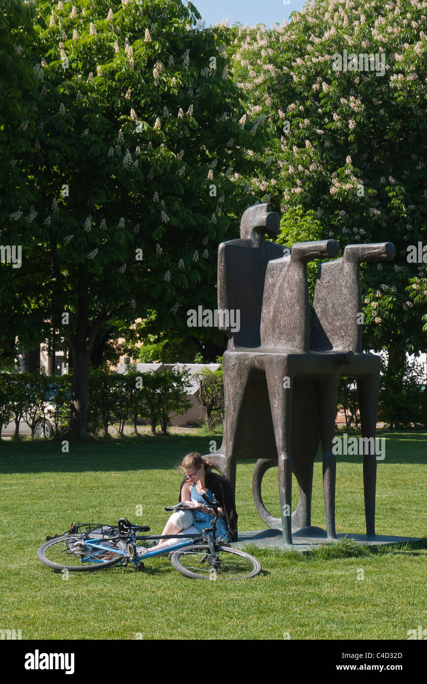 A German university student studies at the base of a sculpture in the ...
